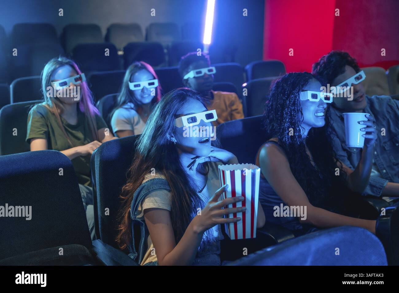 Group of excited young friends wearing 3d glasses, watching a movie at ...