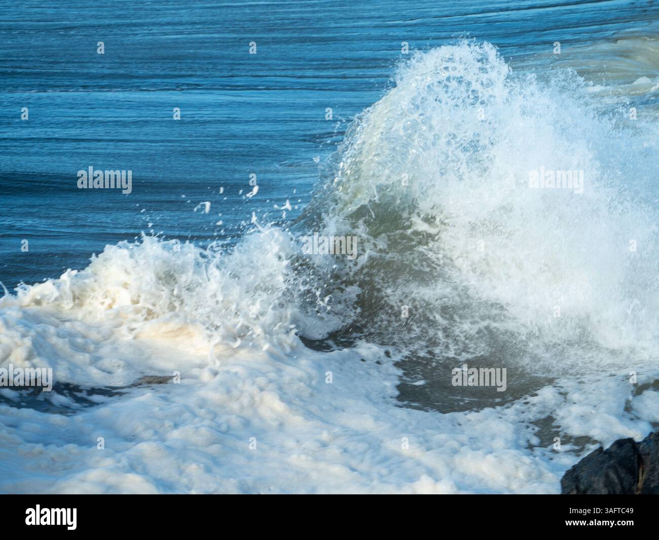Water flying up into the air from a sea wave as it crashes Stock Photo ...