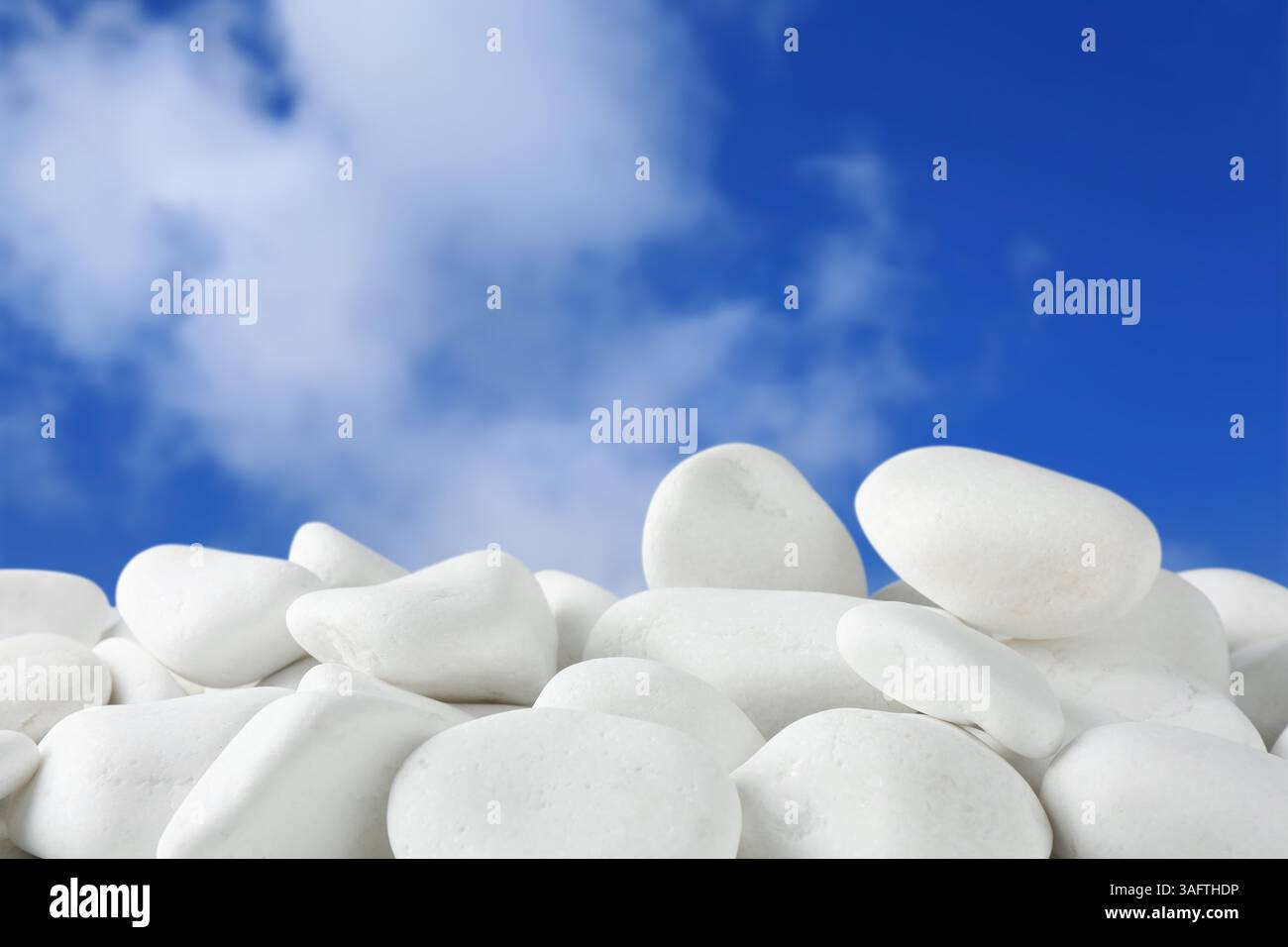 White pebbles against blue sky with clouds Stock Photo - Alamy