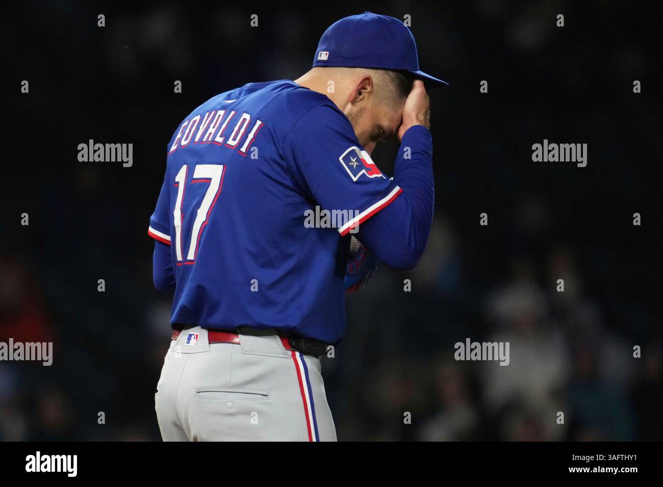 Texas Rangers starting pitcher Nathan Eovaldi wipes his face during the third inning of a ...