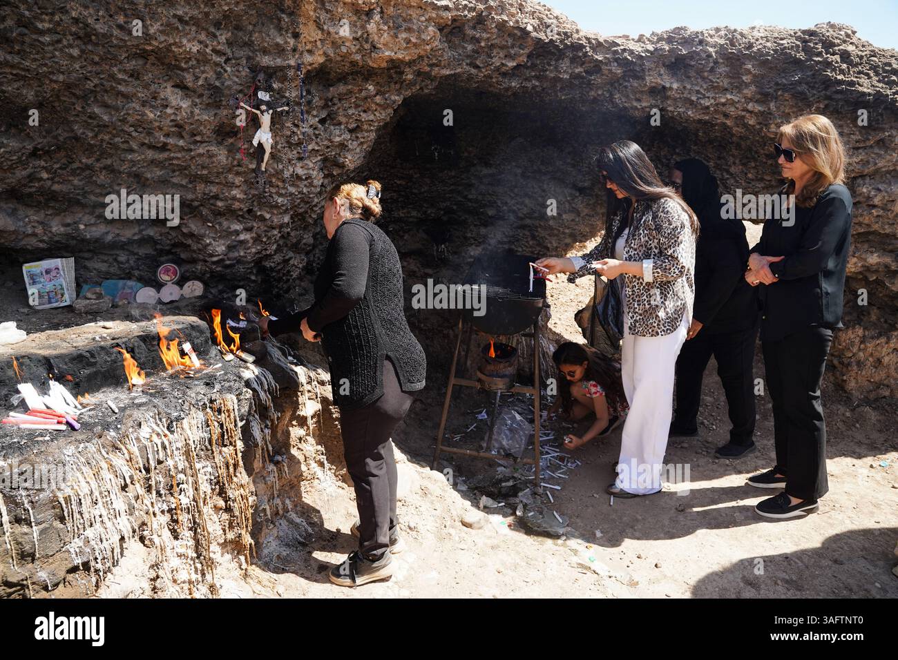 Qaraqosh, Iraq. 06th Apr, 2025. Iraqi Christian women pray on the ruins ...