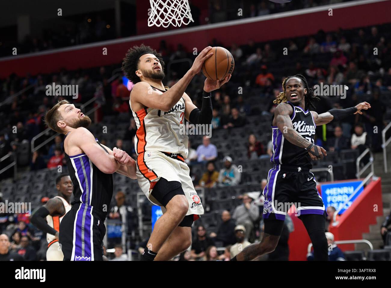Detroit Pistons guard Cade Cunningham,center, goes to the basket ...