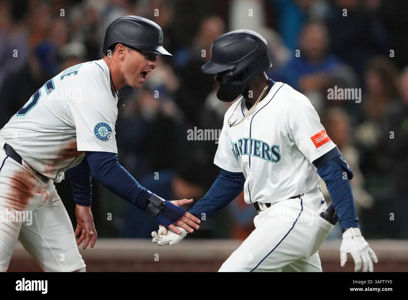 Seattle Mariners' Dylan Moore, left, greets teammate Ryan Bliss, right ...