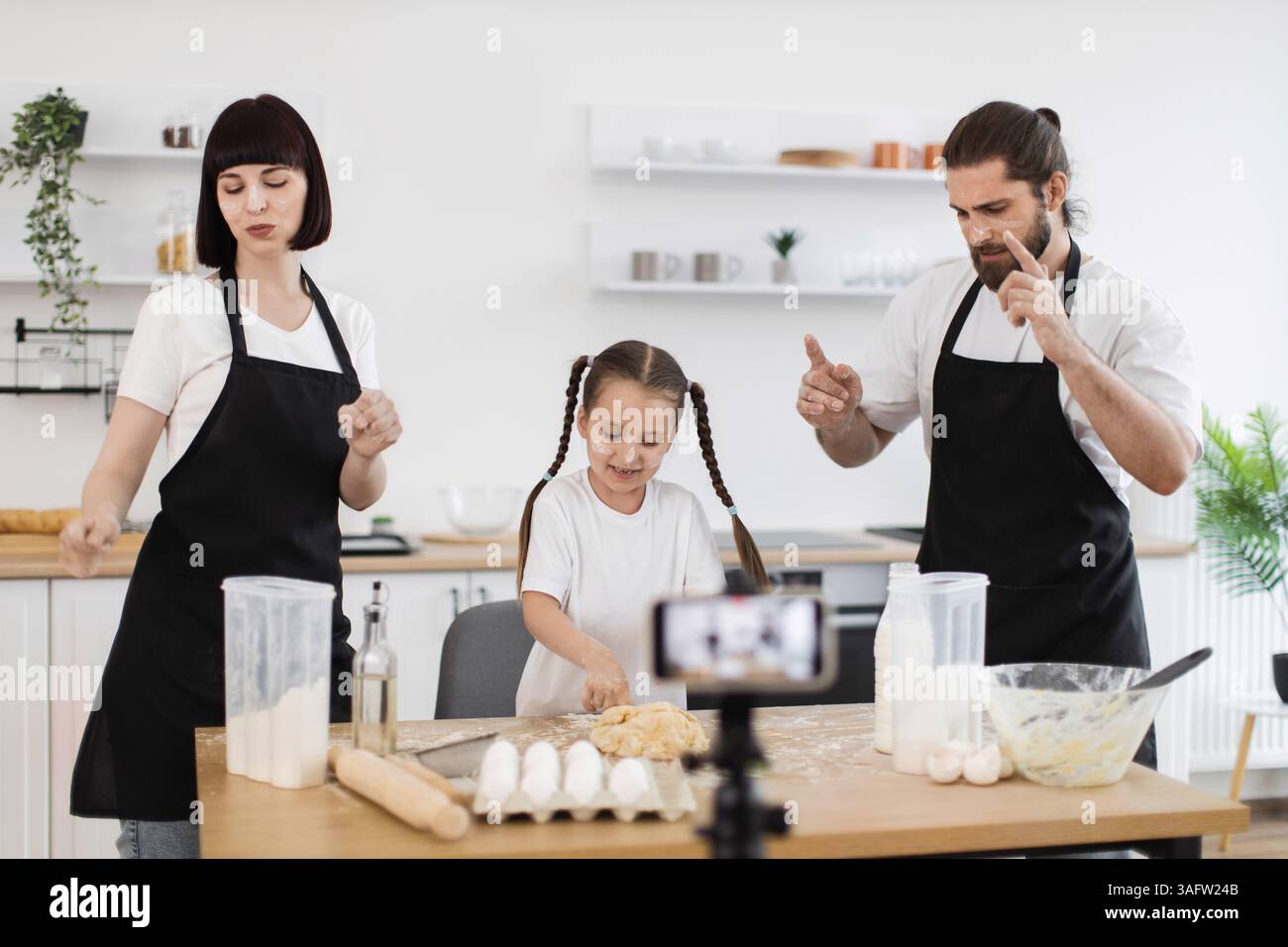 Family baking session while streaming live in a modern kitchen setup ...