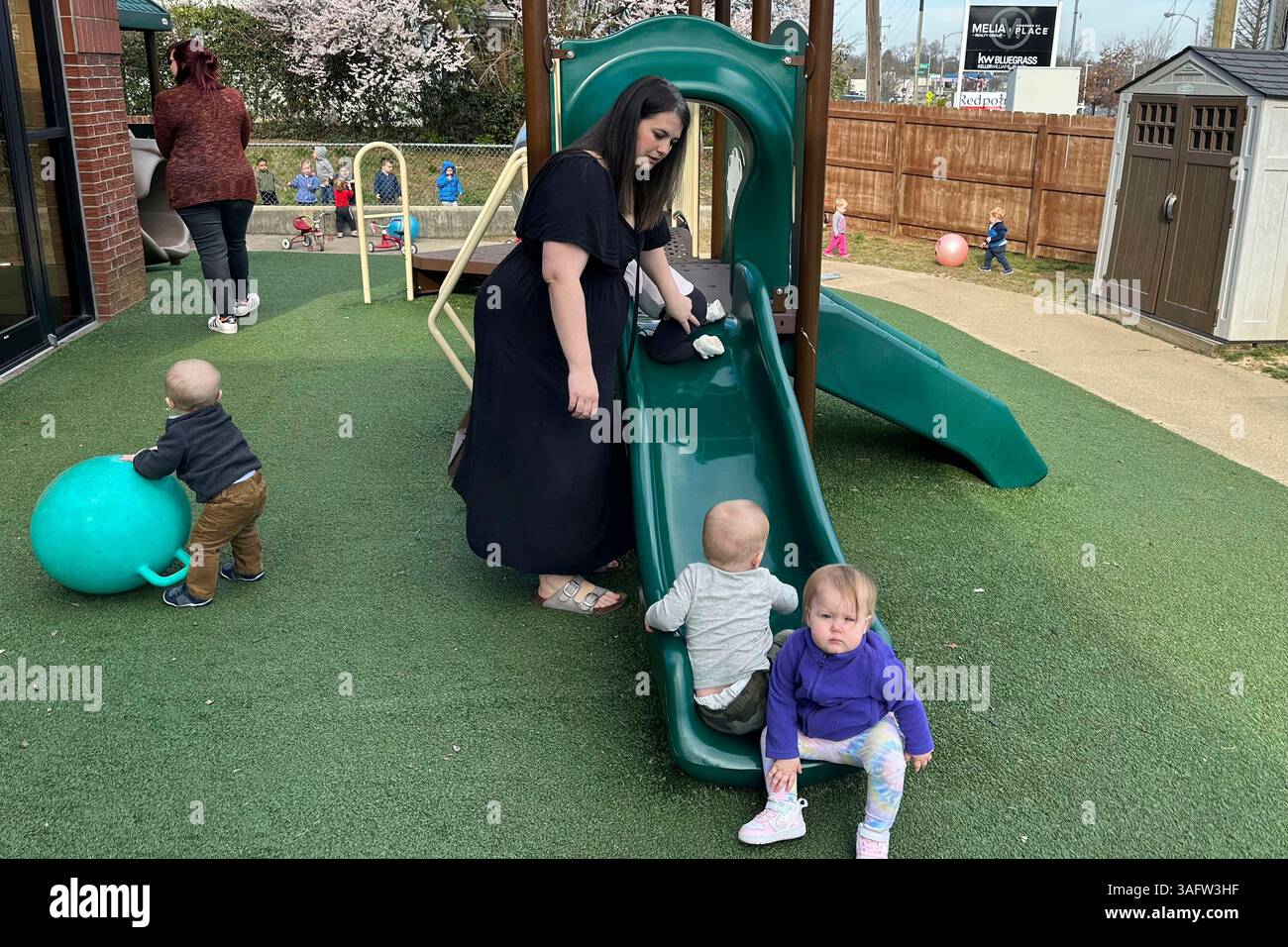 FILE - Delaney Griffin, center, plays with toddlers at the child care ...