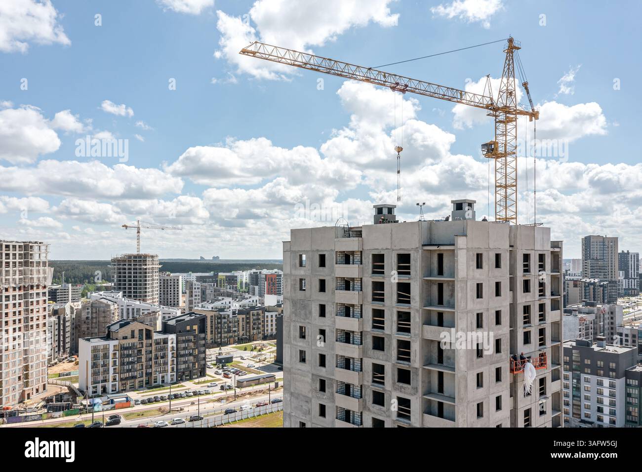 apartment buildings under construction and crane on residential area ...