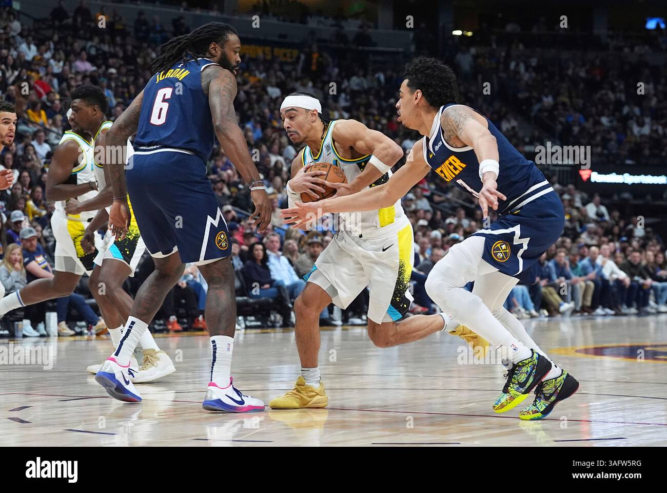 Indiana Pacers guard Andrew Nembhard (2) drives betwen Denver Nuggets ...