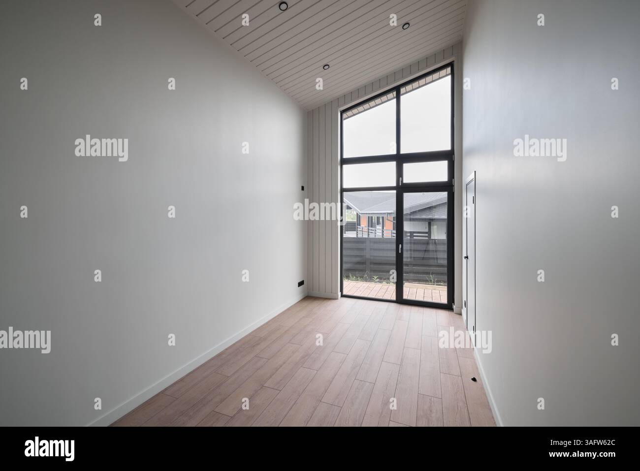 A Minimalist Interior Space Featuring Large Windows That Allow for ...