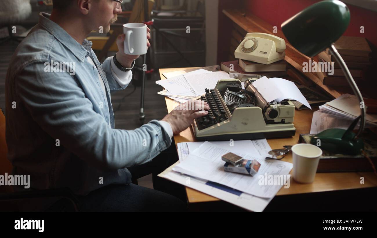 A male journalist smokes and writes his article intensely. Vintage ...