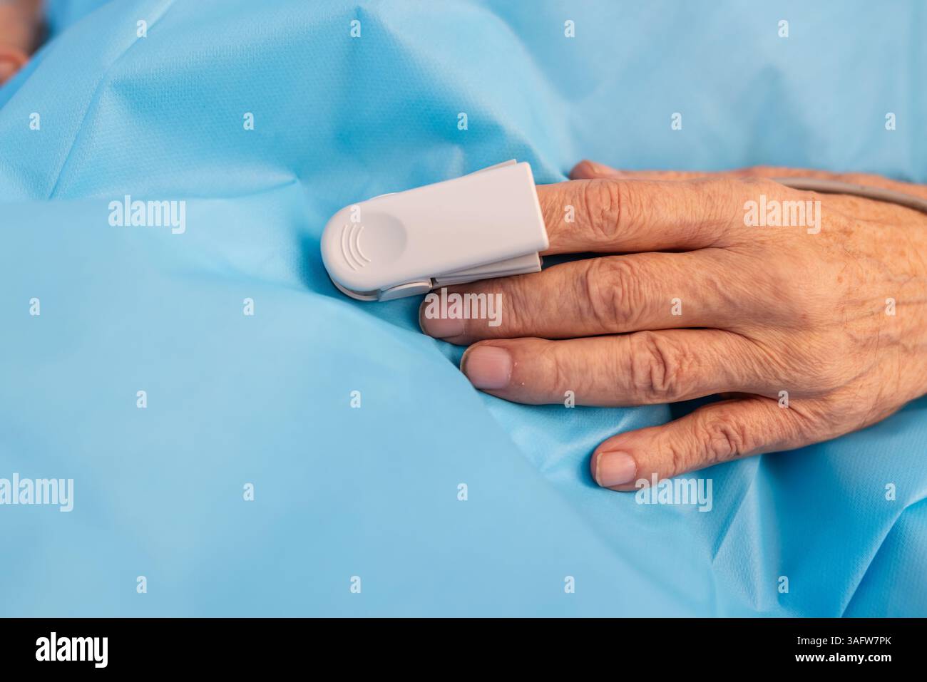 Close-up of senior patient's hand with pulse oximeter on finger ...