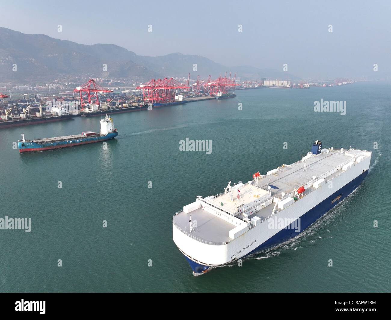 A cargo ship slowly leaves its berth at the container terminal in ...