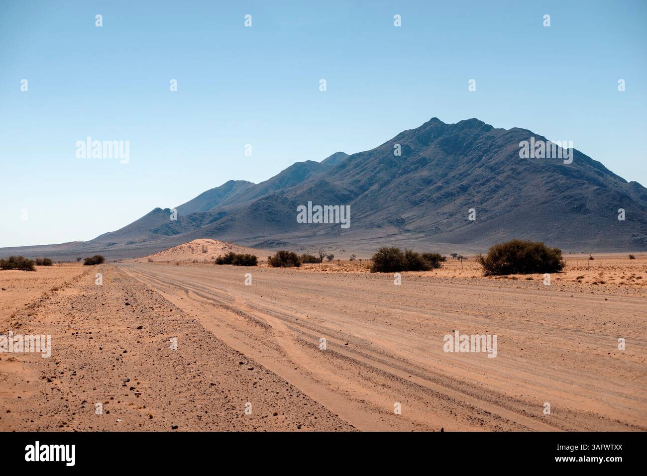 empty gravel road in desert leading toward the mountain in Namibia ...