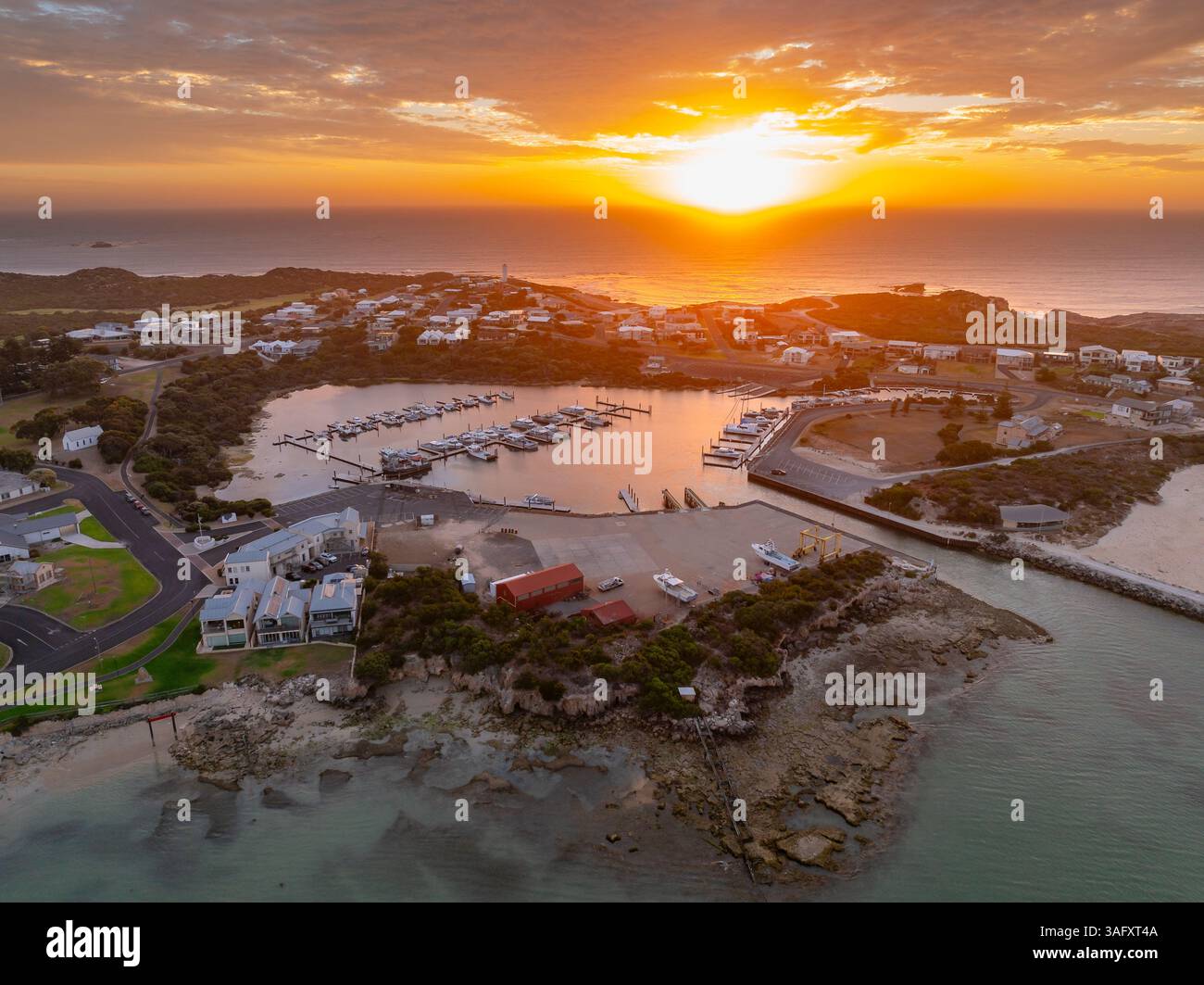 Aerial view of a dramatic sunset over a coastal harbor and surrounding ...
