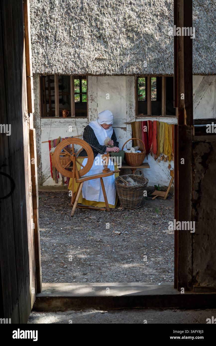 Woman dressed in period costumes with a 17th century spinning wheel at ...