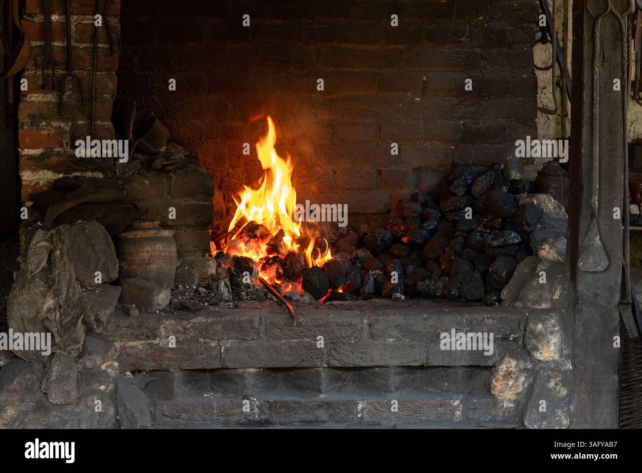 Coals and fire in an old fashioned blacksmiths forge Stock Photo - Alamy