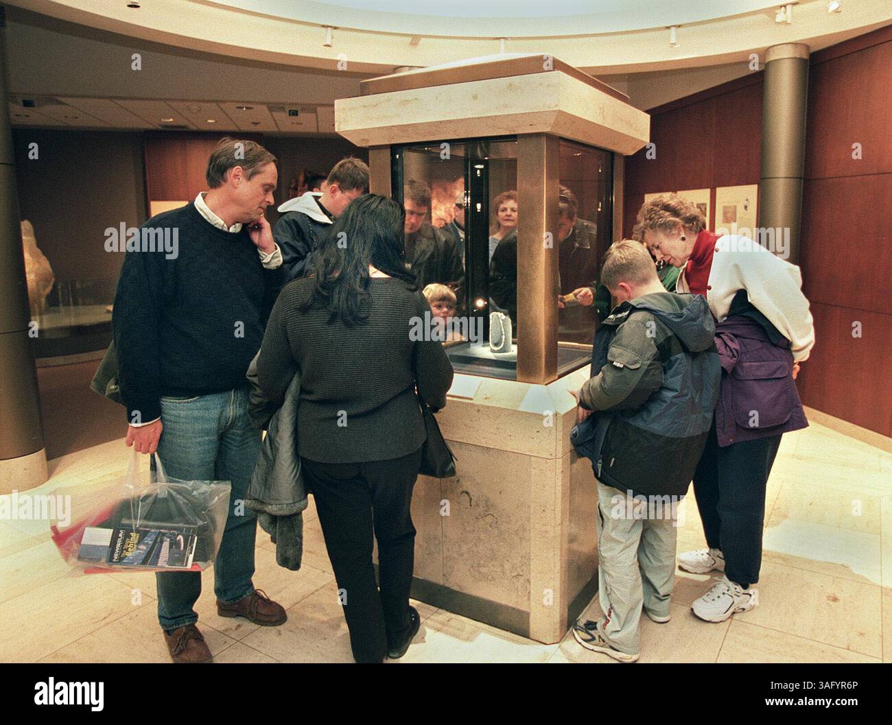 A group of visitors gathers to look at the Hope Diamond on display in a ...