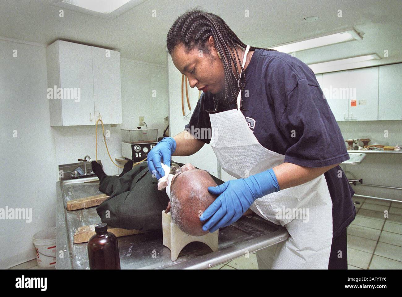 Mortician Janet Anderson prepares a body for viewing in the morgue at ...