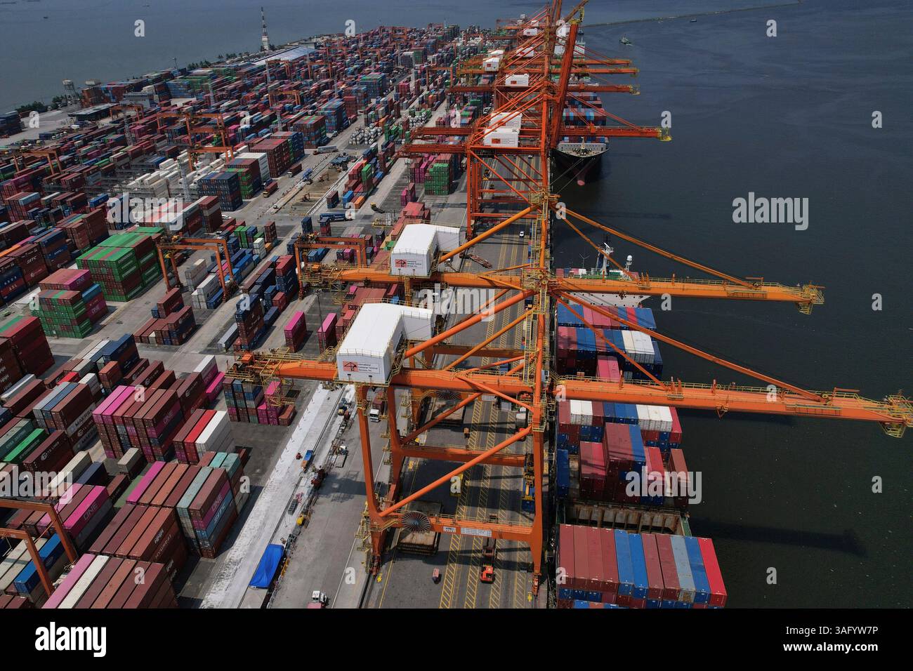 Cranes work on stacks of containers at the Manila International ...