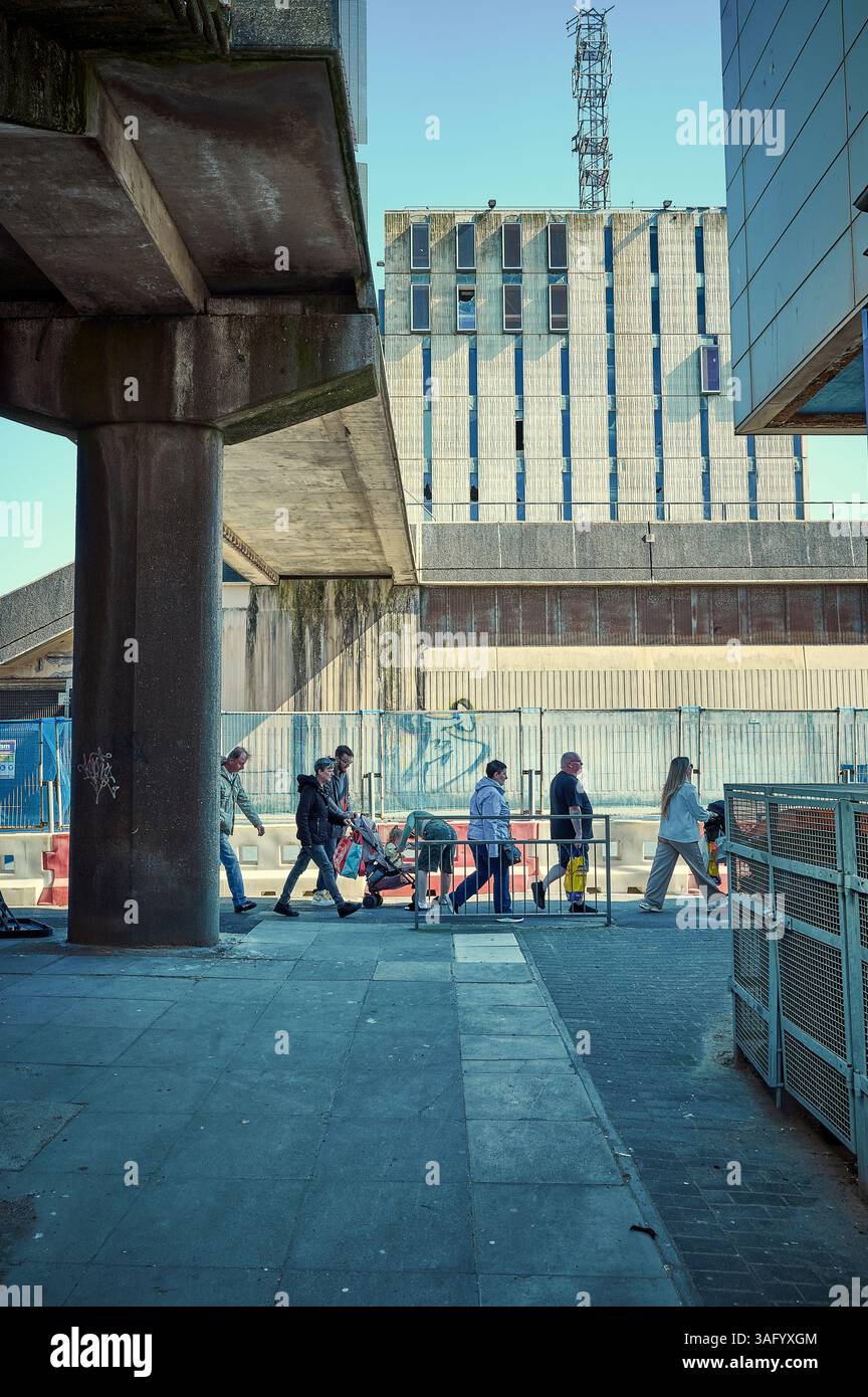 Pedestrians walk single file past cordoned off demolition site Stock ...