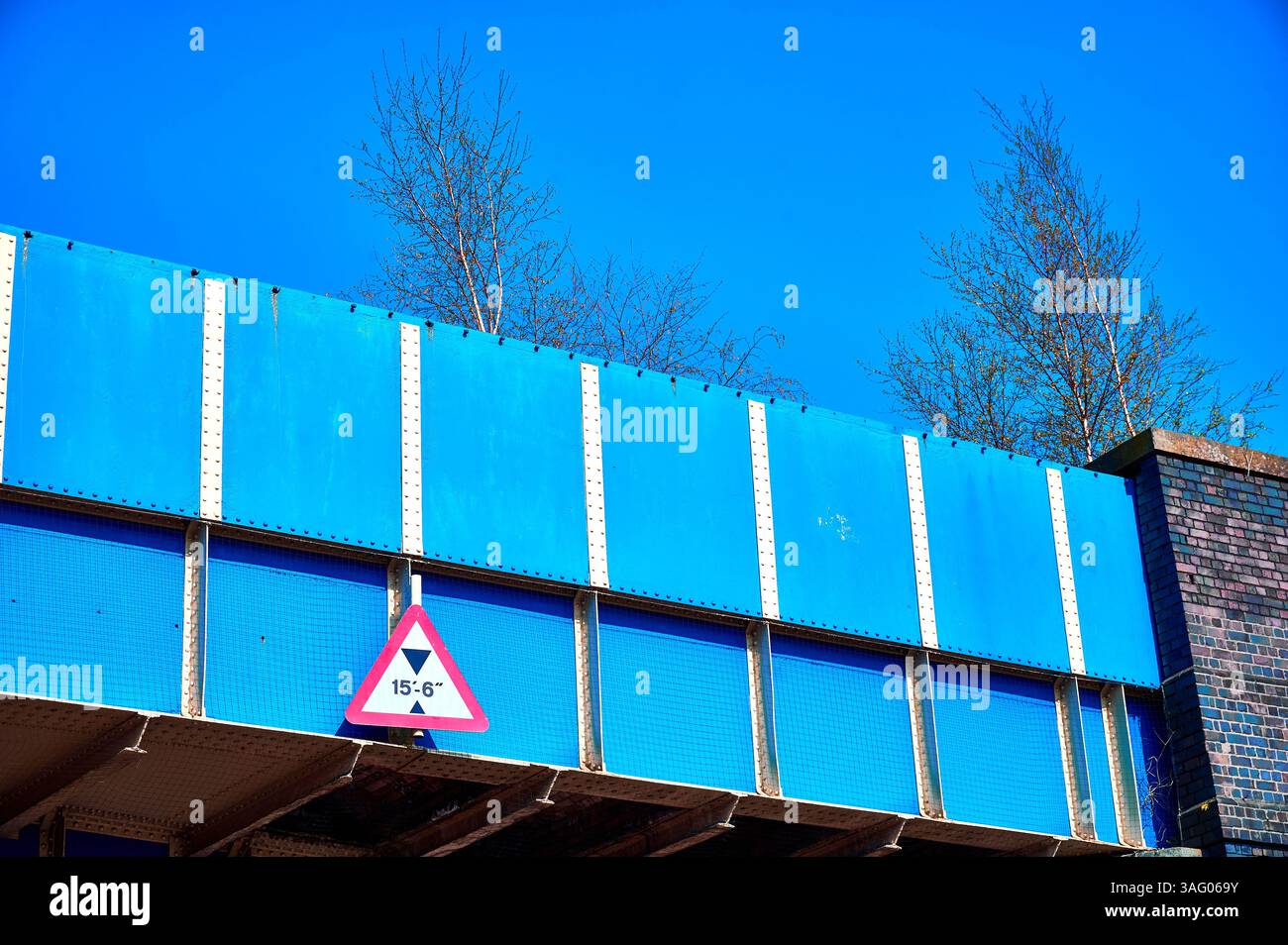Height restriction sign under blue railway bridge Stock Photo - Alamy