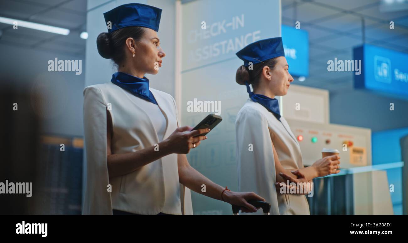 Two Beautiful Flight Attendants in Elegant Uniforms Talking, Waiting ...