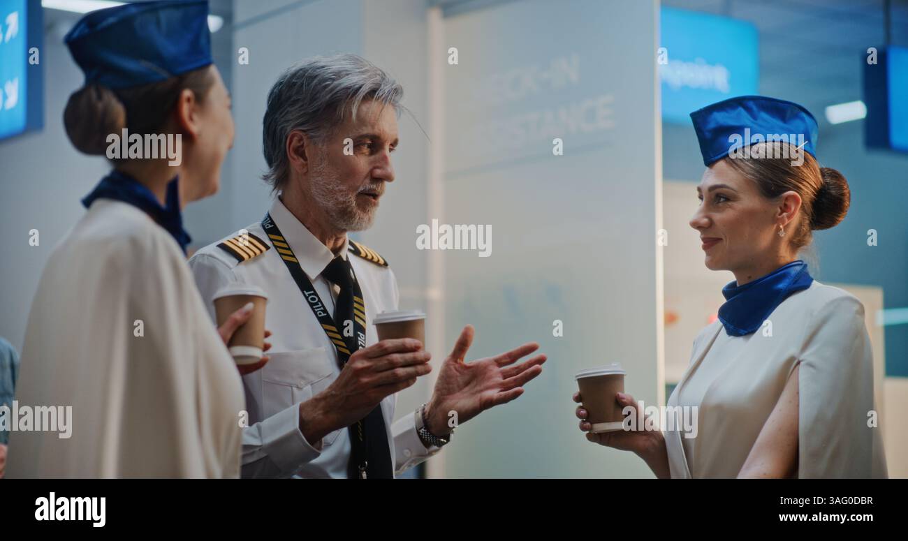 Flight Crew: Mature Airline Pilot Communicating with Two Beautiful Flight Attendants in Uniforms ...