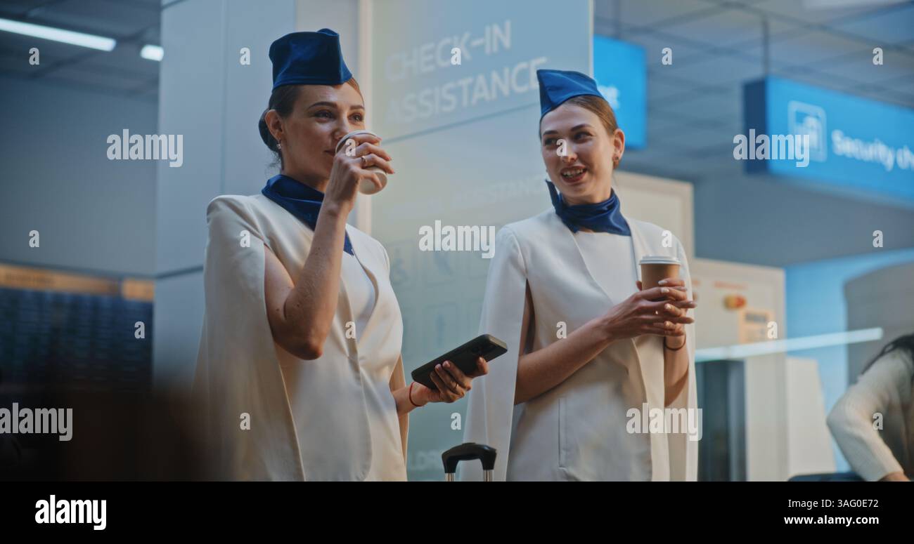 Two Beautiful Flight Attendants in Elegant Uniforms Talking, Waiting ...