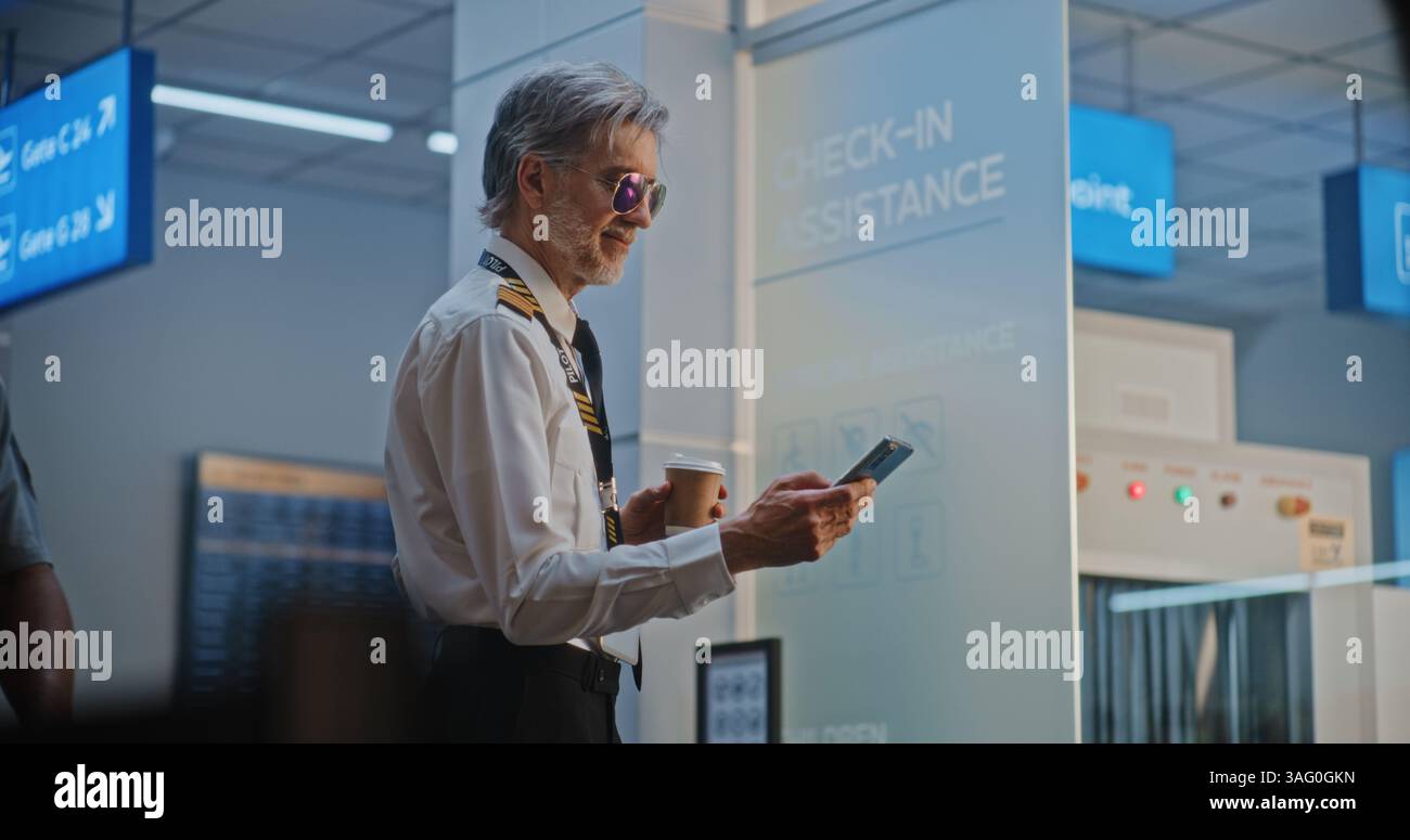 Professional Airline Pilot in Uniform Drinking Coffee, Using Smartphone ...