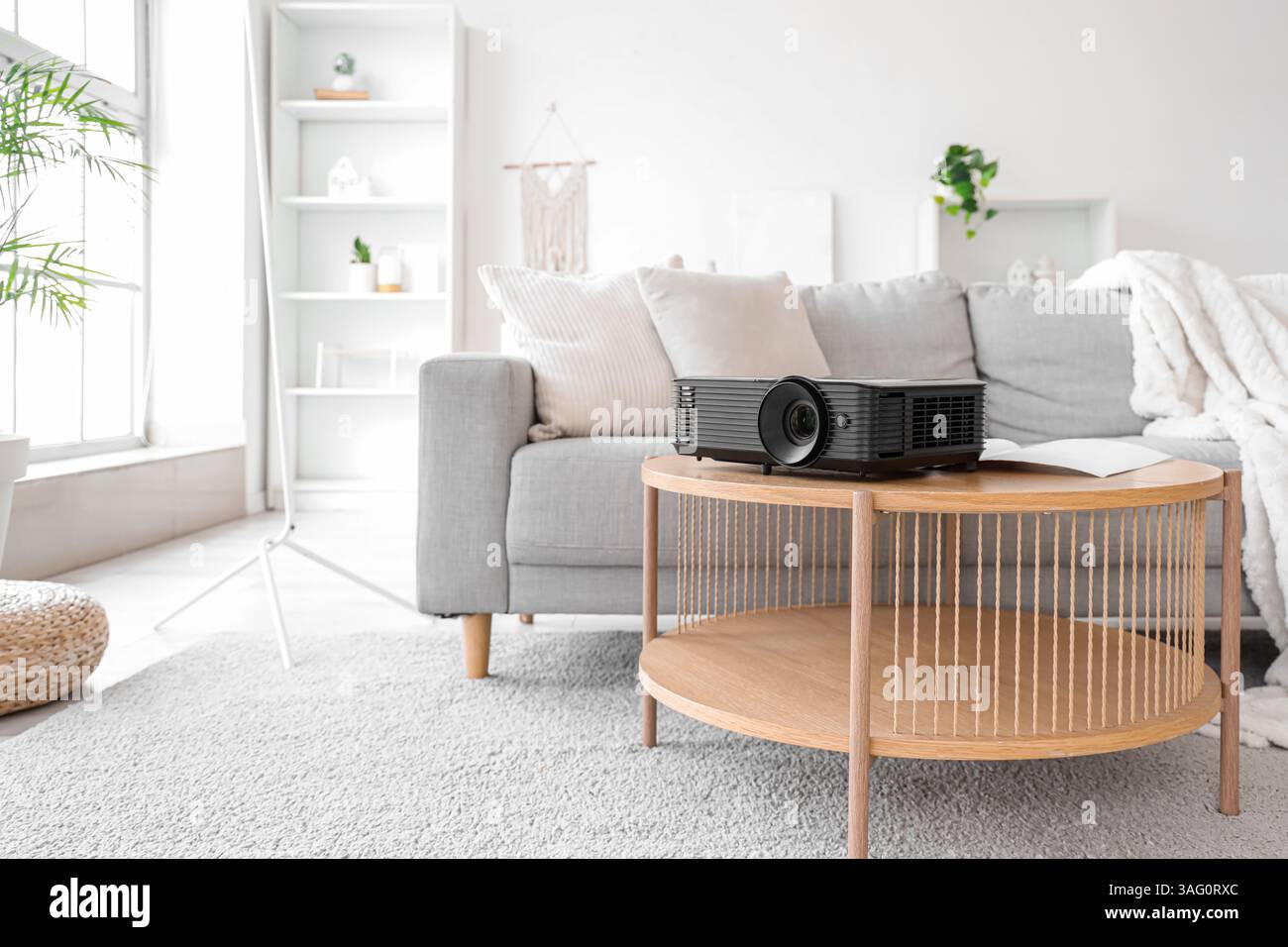 Modern projector on table in living room interior Stock Photo - Alamy