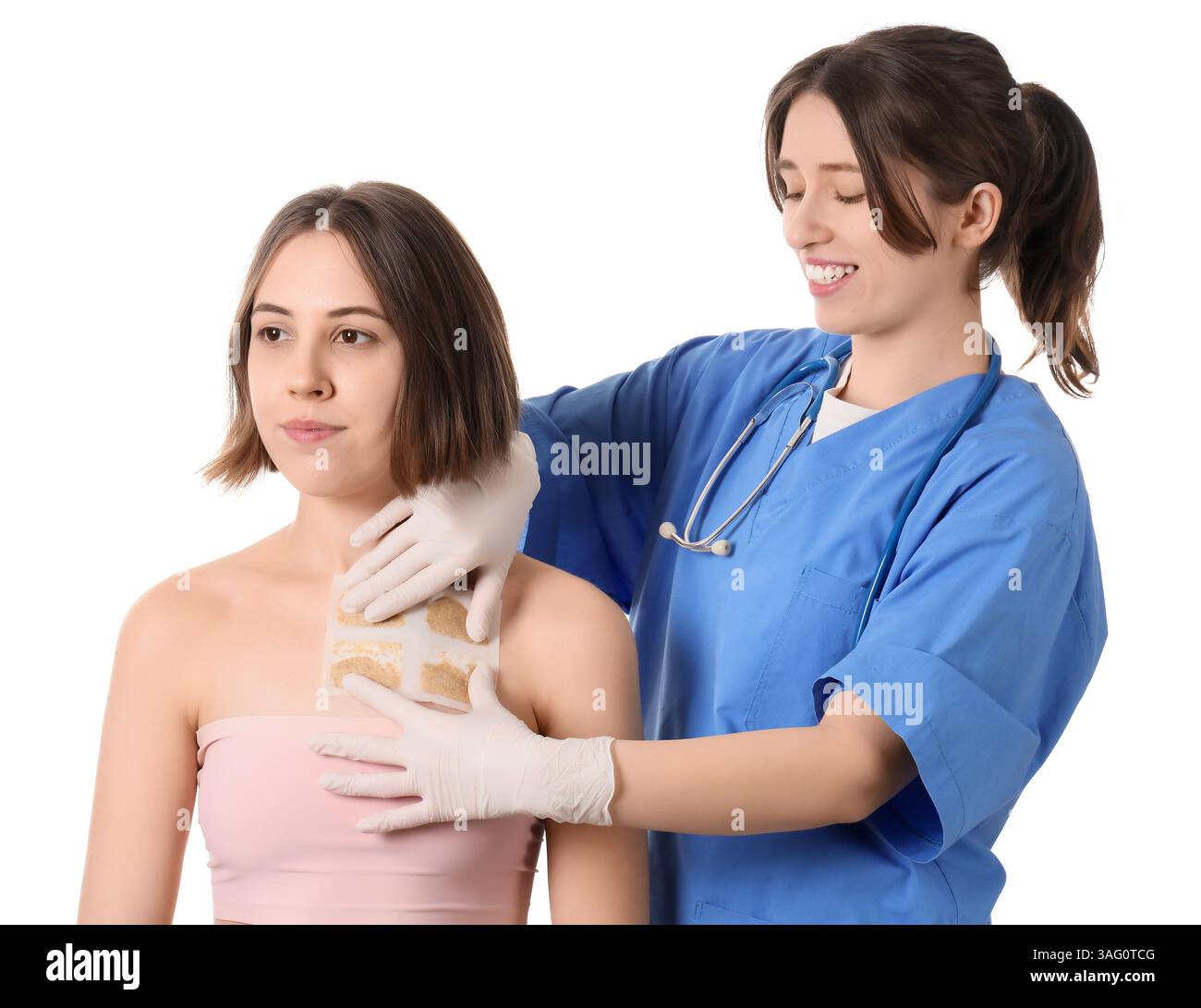 Female doctor applying mustard plaster on patient's chest against white ...