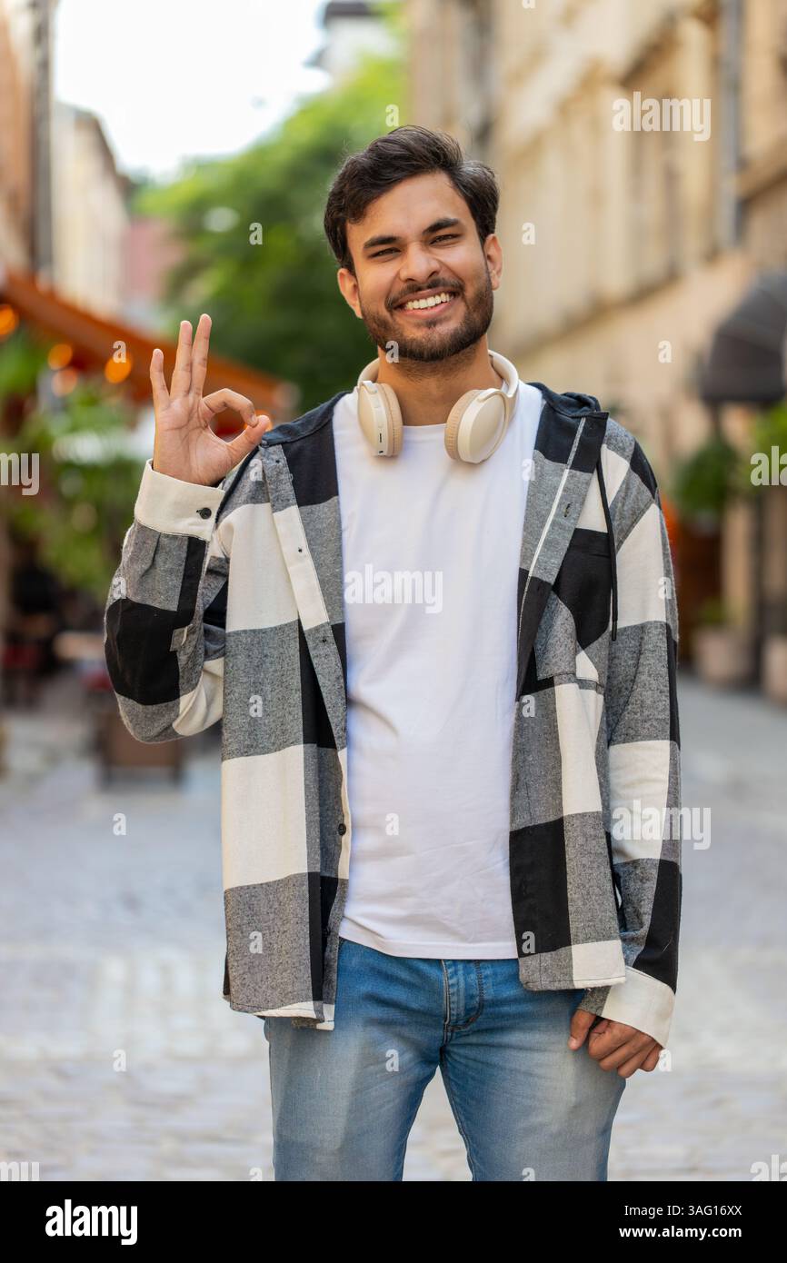 Okay. Happy cheerful young Indian man looking approvingly at camera ...