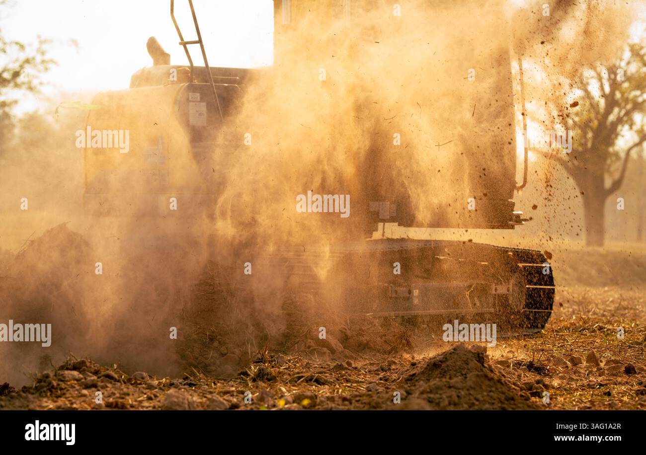 Hydraulic excavator operating at a worksite, moving earth and preparing ...