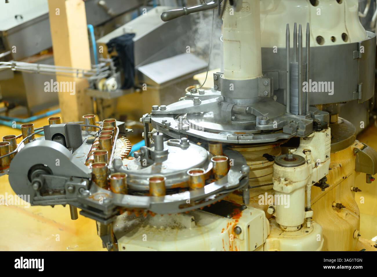Close up of automated food processing machinery filling metal cans in a ...