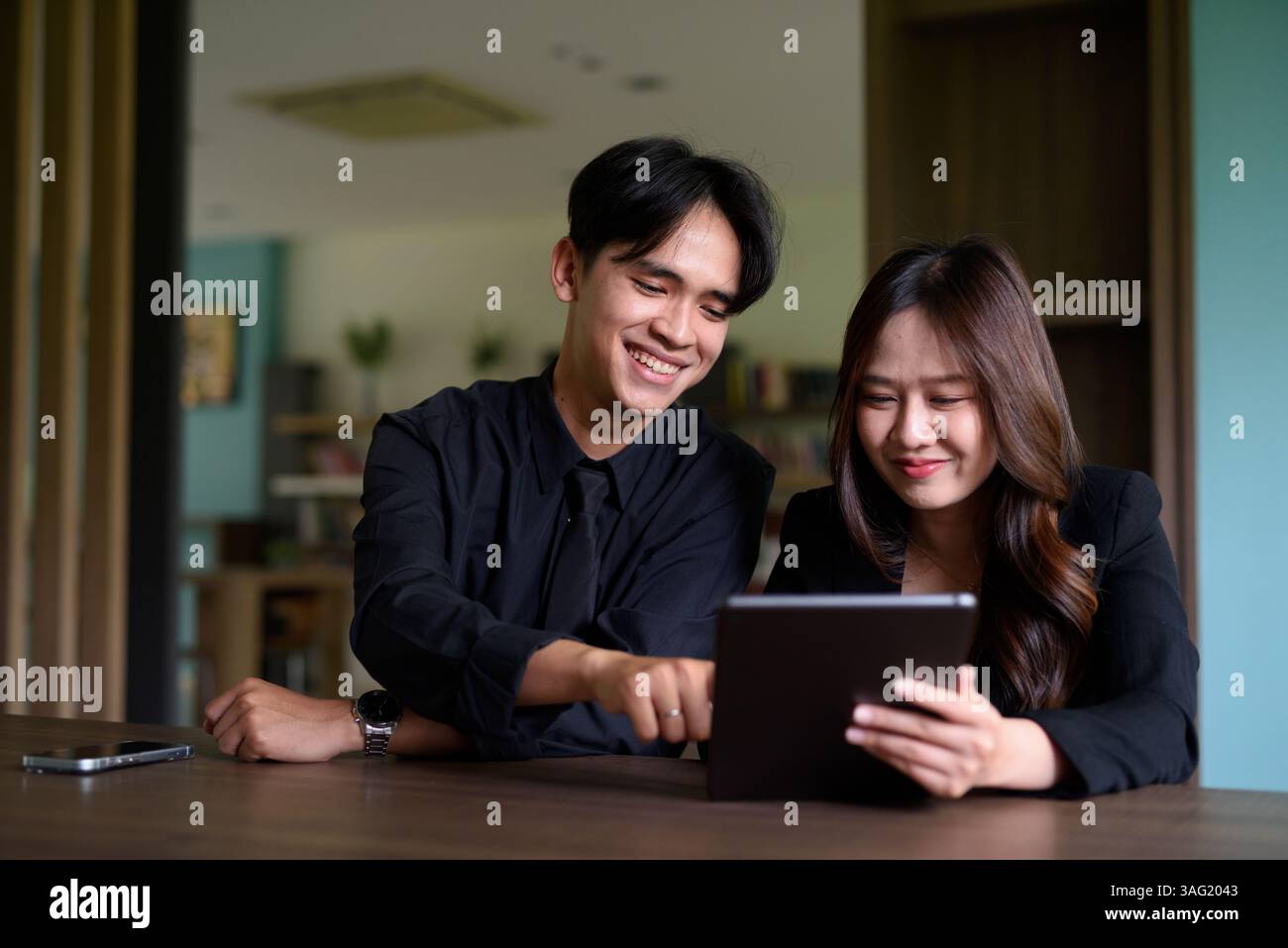 Young Asian couple sitting together in library in business uniform Stock Photo - Alamy
