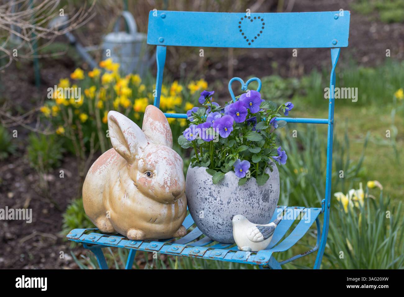 easter bunny and blue viola flower in a pot on the garden chair Stock ...