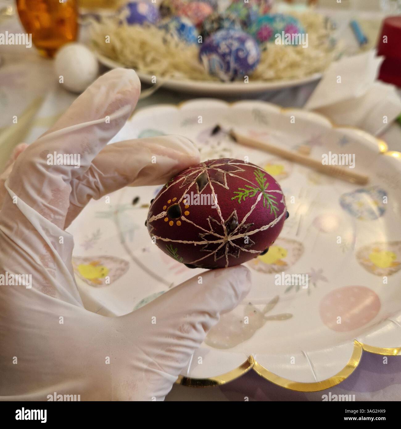 Skilled artisan carefully decorates an Easter egg using the traditional ...