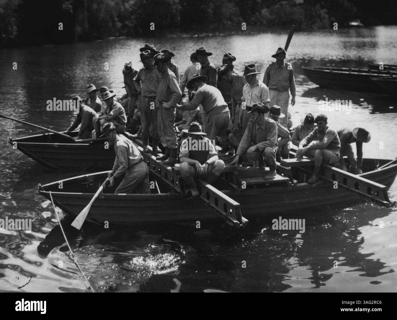 Two rowing-boats are used to carry these girders across a river where ...