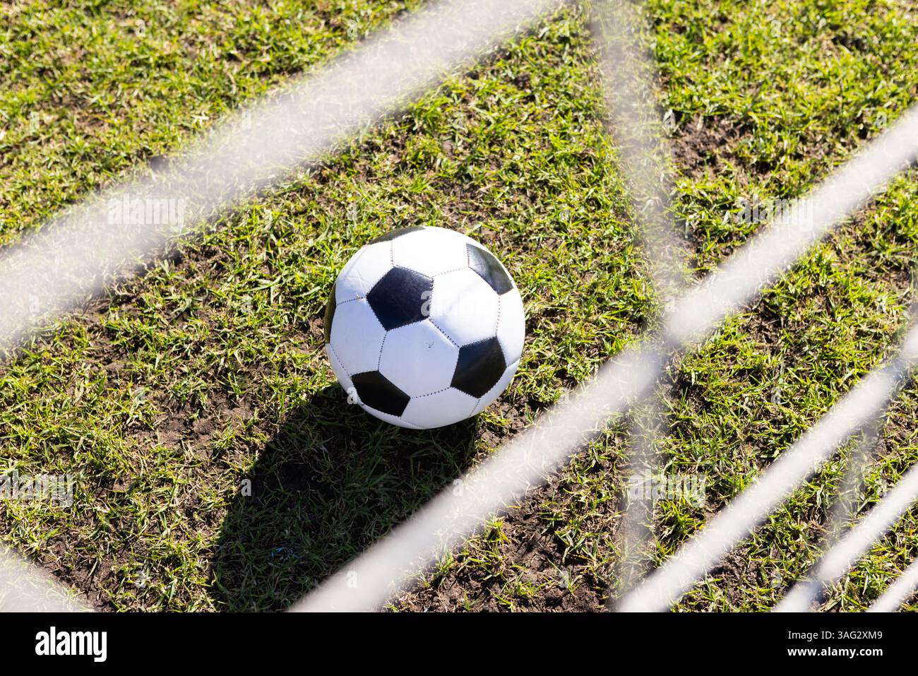 Soccer ball on grass field behind goal net in school playground Stock ...