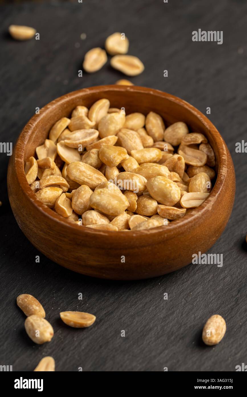 roasted peanuts in a wooden round bowl, crunchy peanuts without shells ...
