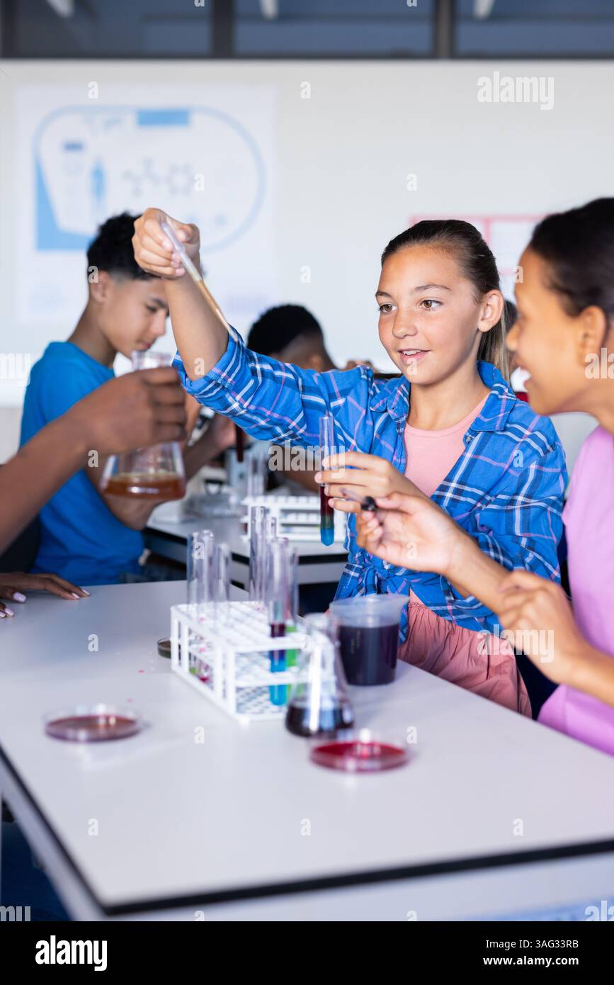 In school, students conducting science experiment with test tubes in ...