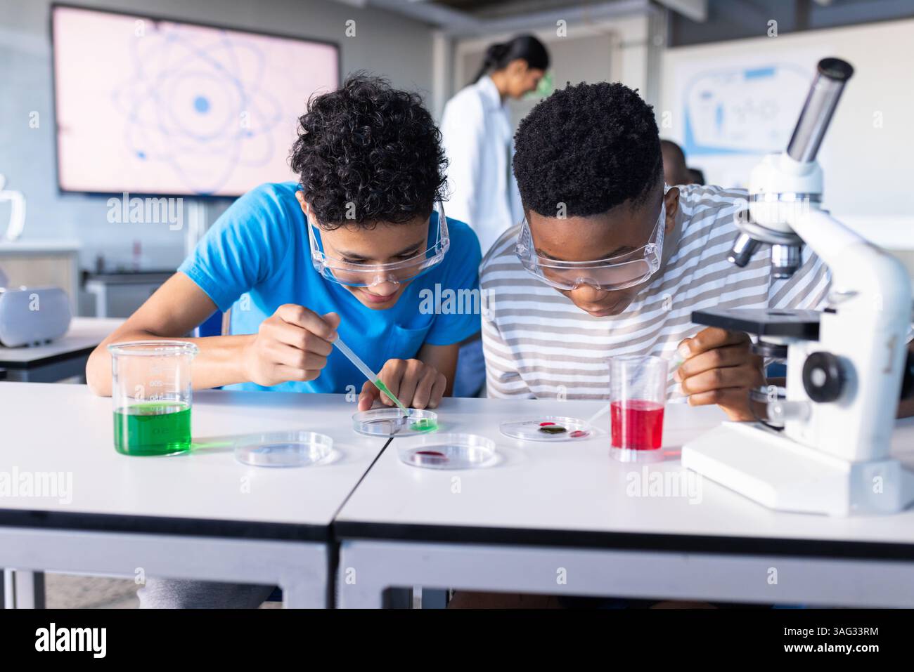 Conducting science experiment with beakers and microscope, students in ...