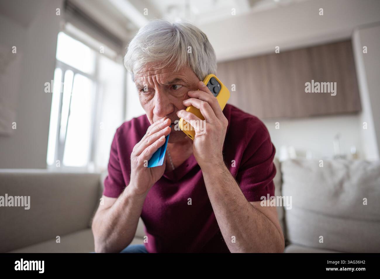 Frightened elderly man hold credit card during suspicious phone call at ...