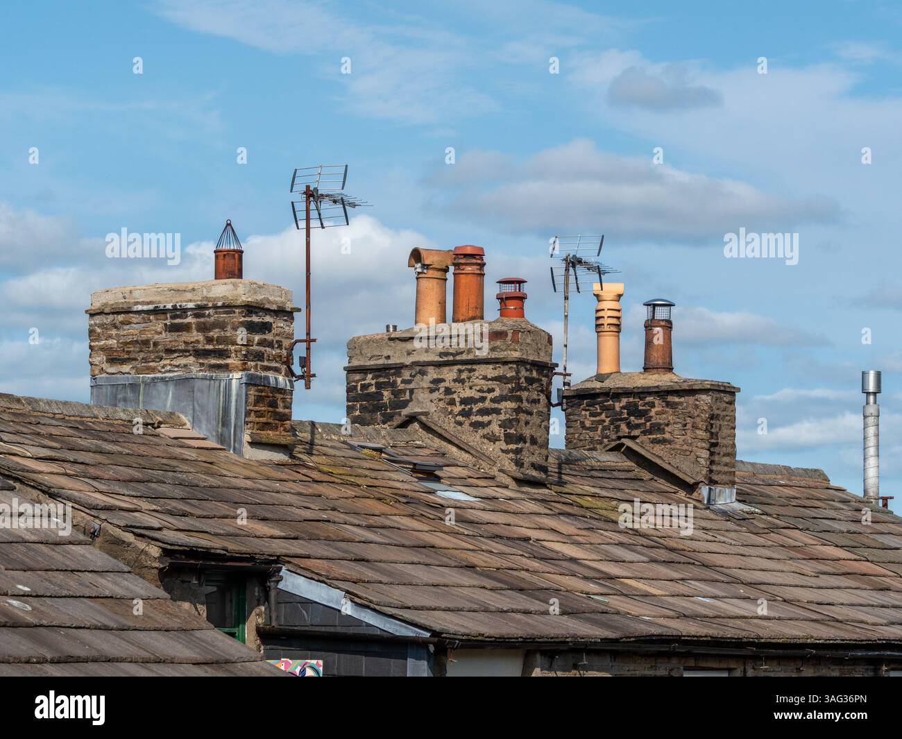 Slate-tiled rooftop with stone chimney stacks on traditional terrace ...