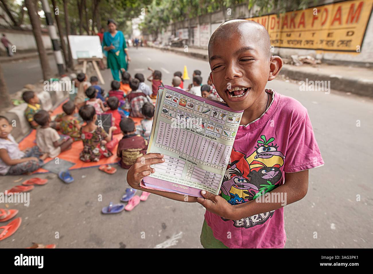 Smiling underprivileged child shows his school report card during a ...