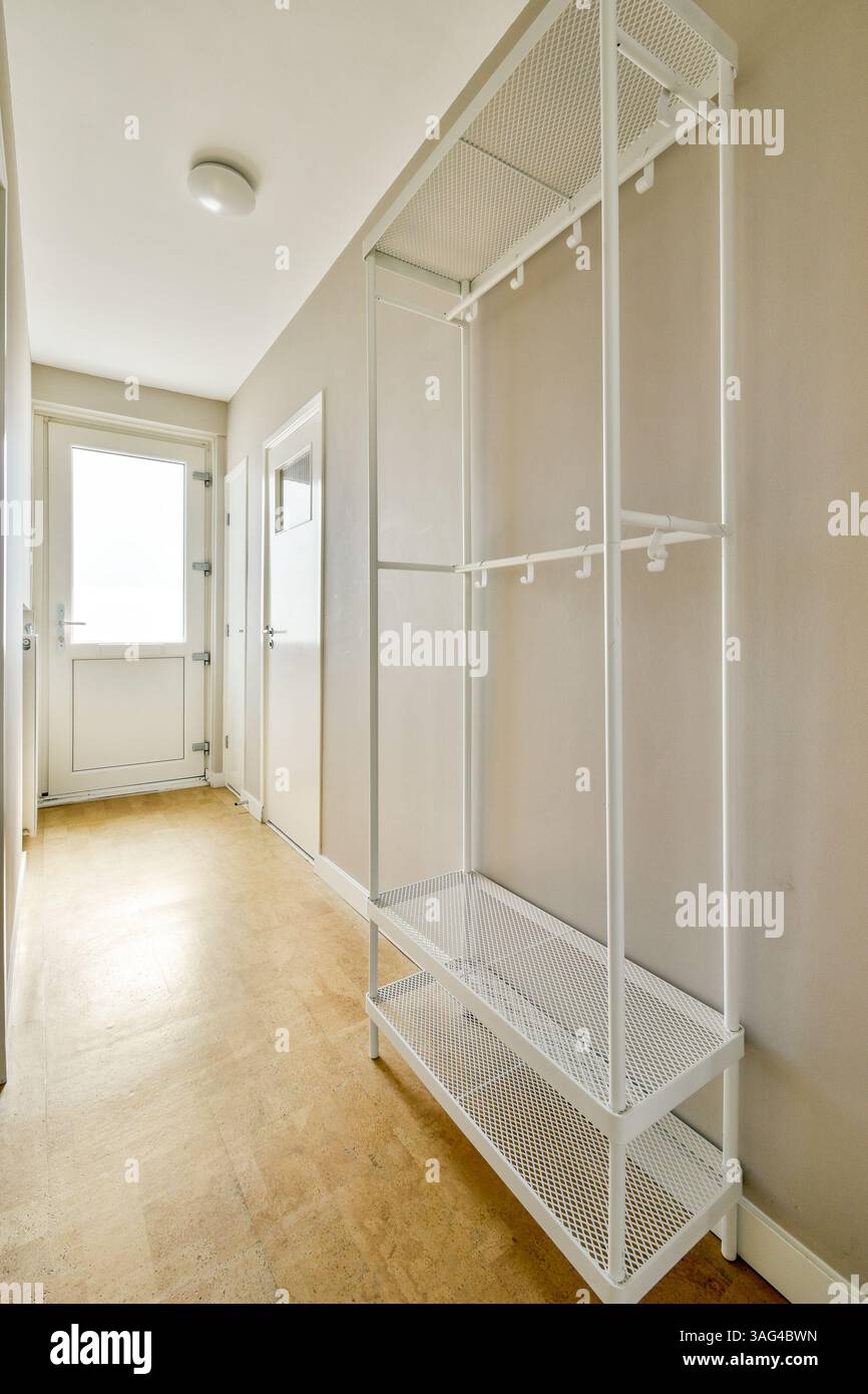 A spacious and well-lit hallway featuring a sleek metal shelving unit ...