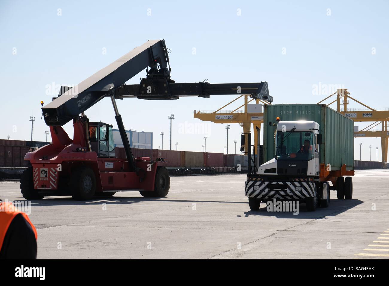 Unloading containers at the logistics center. Machines and cranes drag ...