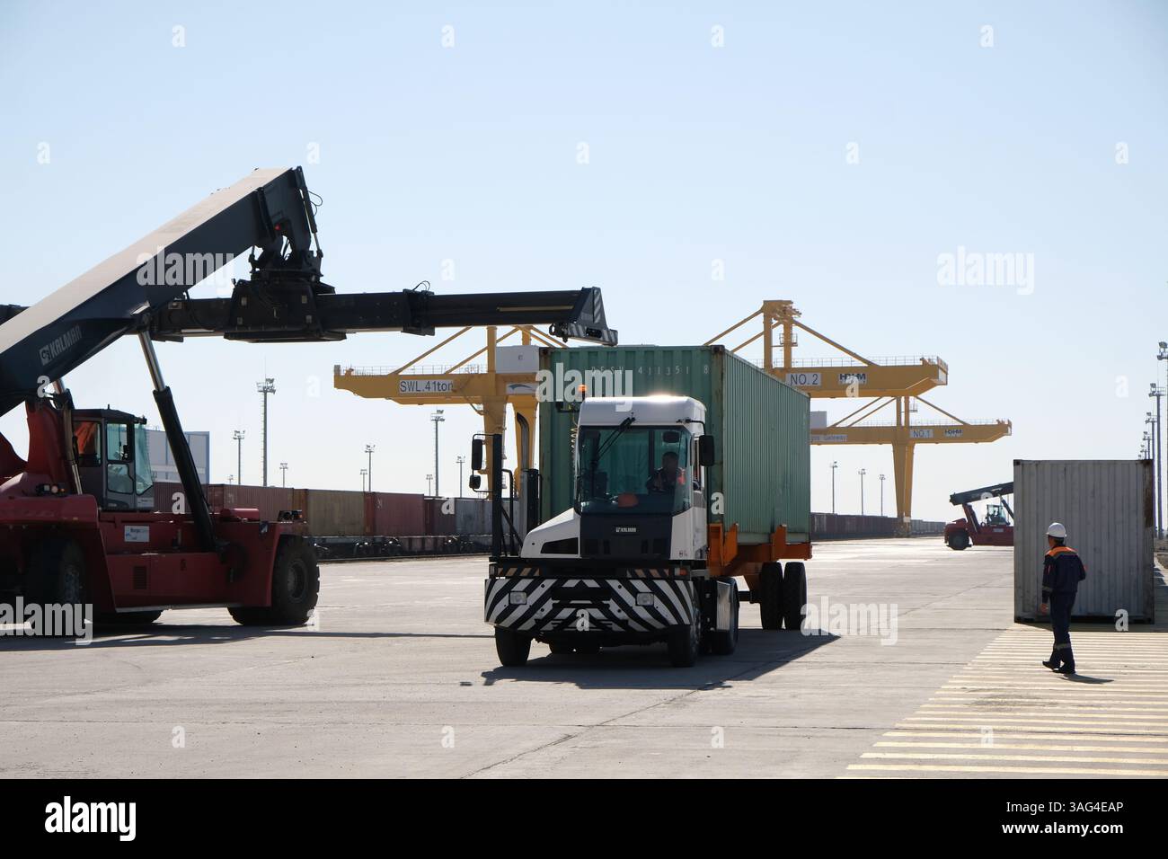 Unloading containers at the logistics center. Machines and cranes drag ...