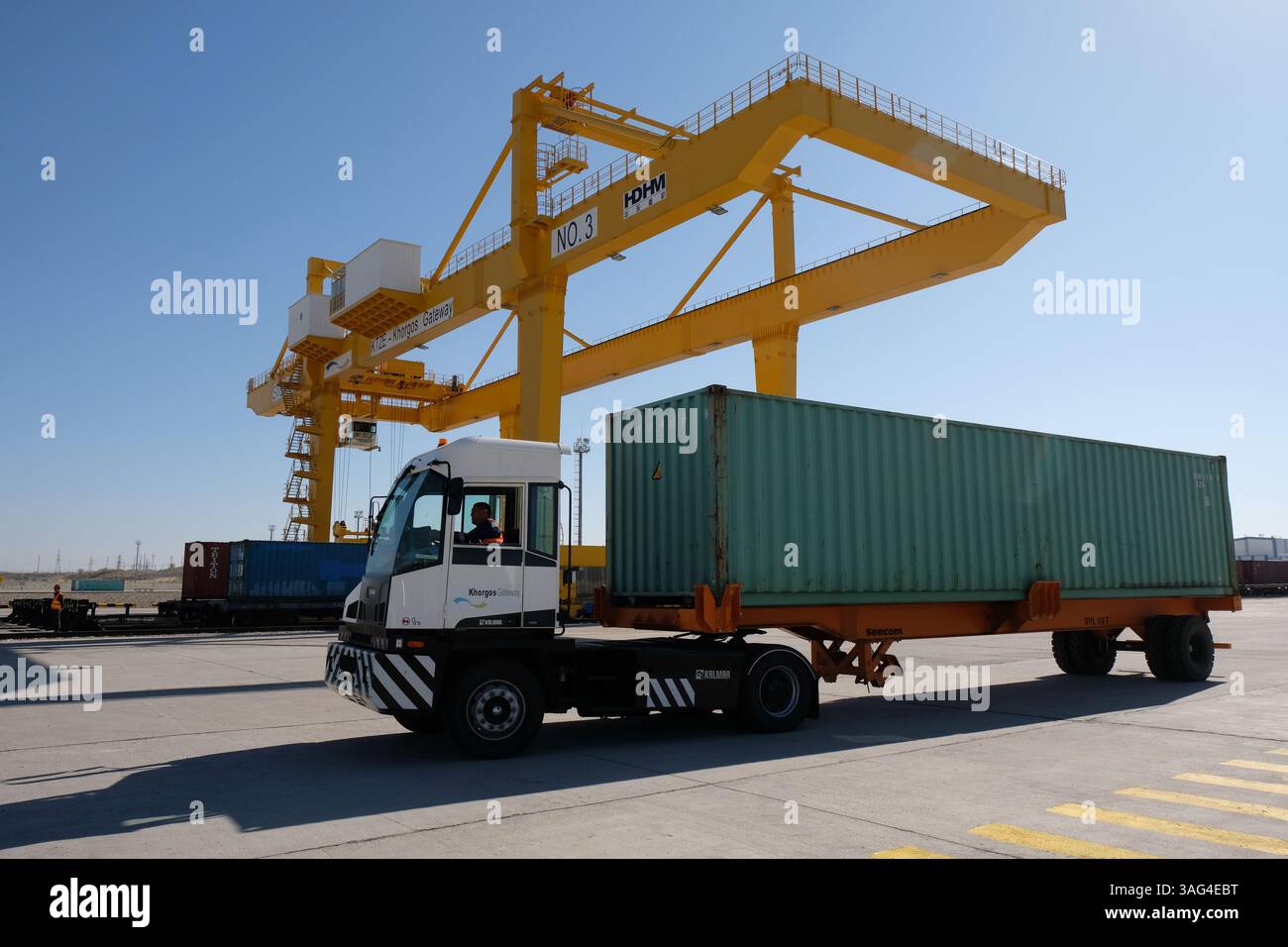Unloading containers at the logistics center. Machines and cranes drag ...