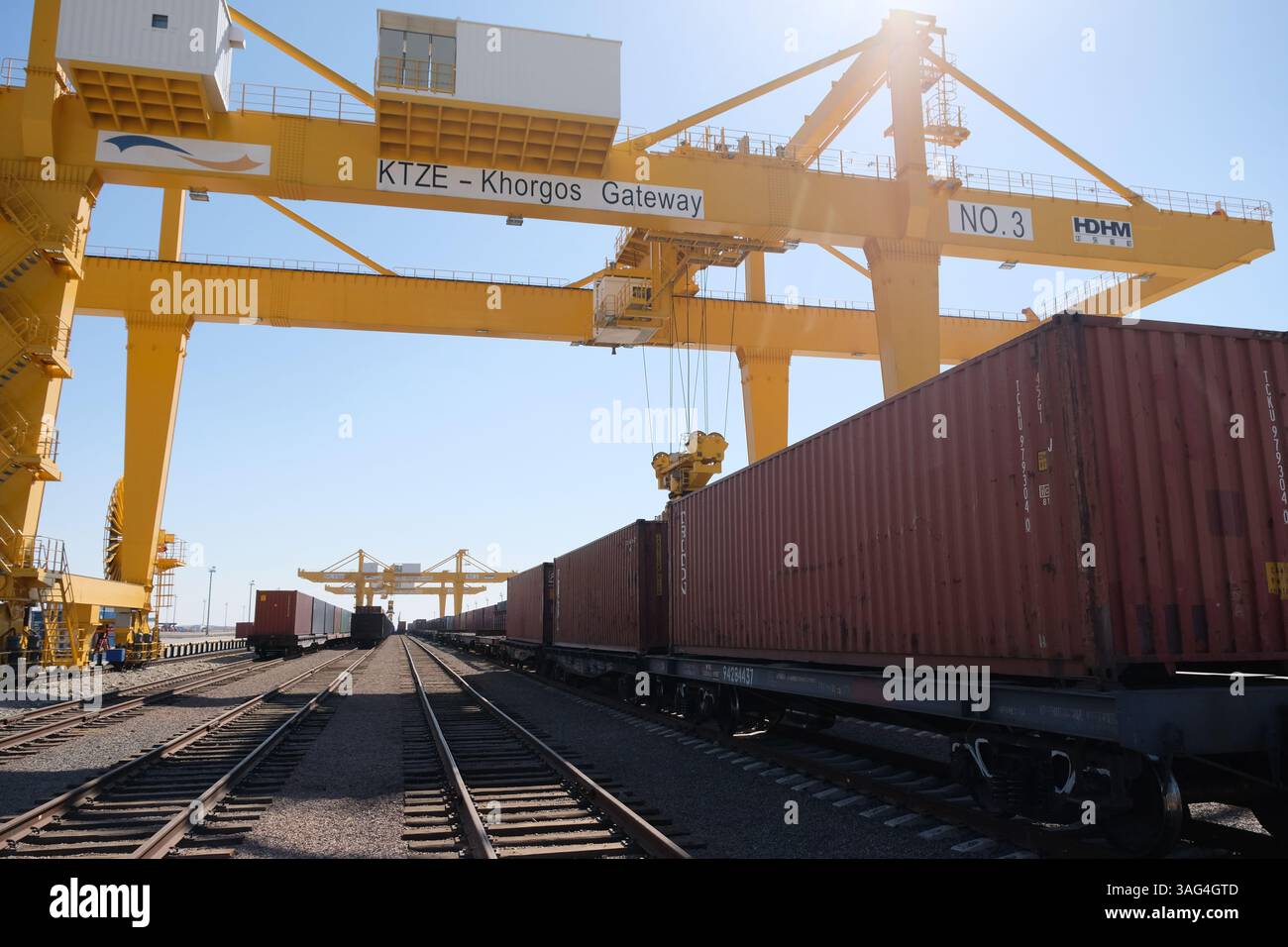 Unloading containers at the logistics center. Machines and cranes drag ...