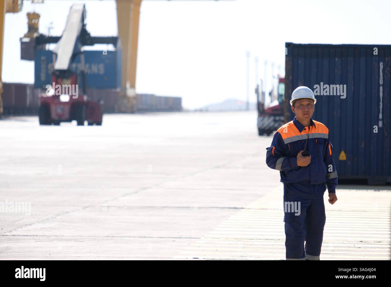 A security and control officer monitors the unloading of containers ...